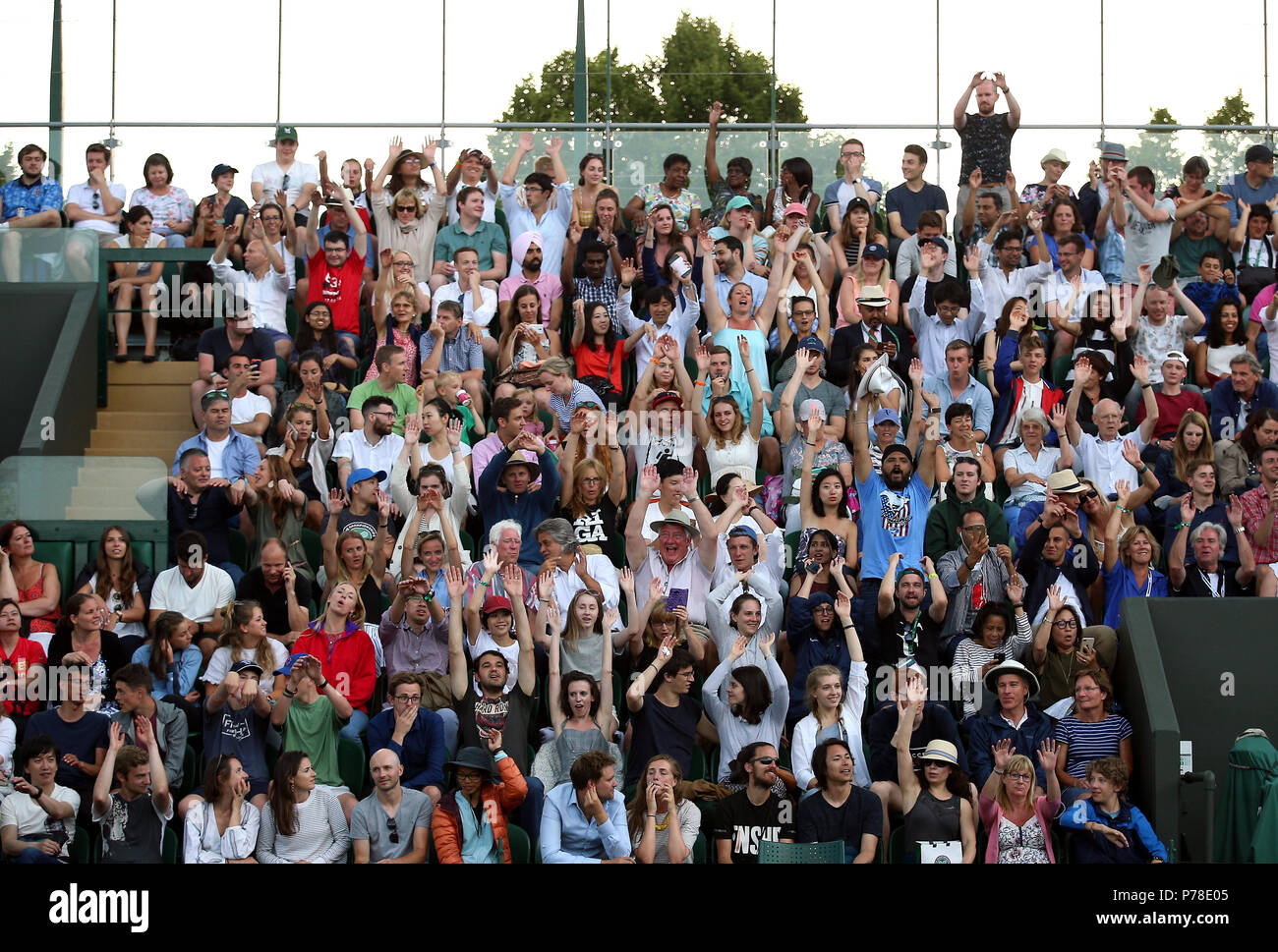 Spectators on court three take part in a mexican wave on day three of ...