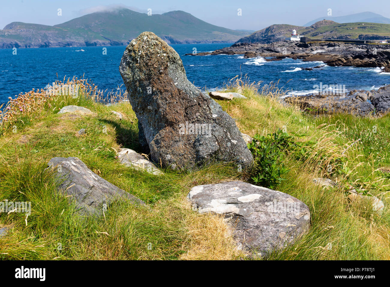 Small standing stone and Valentia Island lighthouse in the background ...