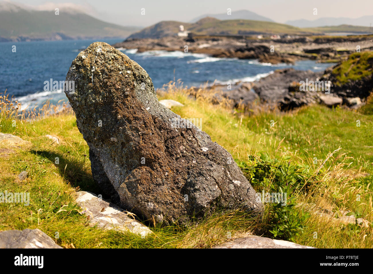 Small standing stone and Valentia Island lighthouse in the background ...