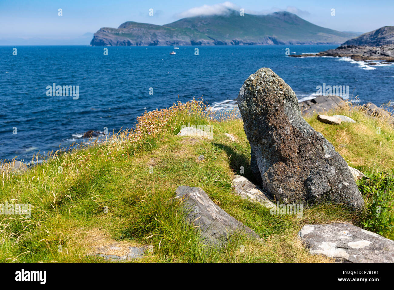 Small standing stone and Valentia Island lighthouse in the background ...