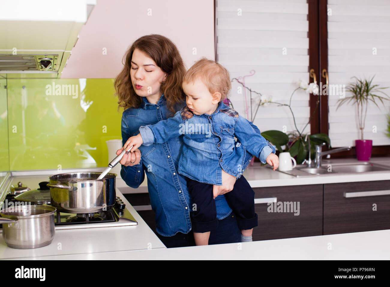 Mother and her son cooking soup in the kitchen Stock Photo - Alamy