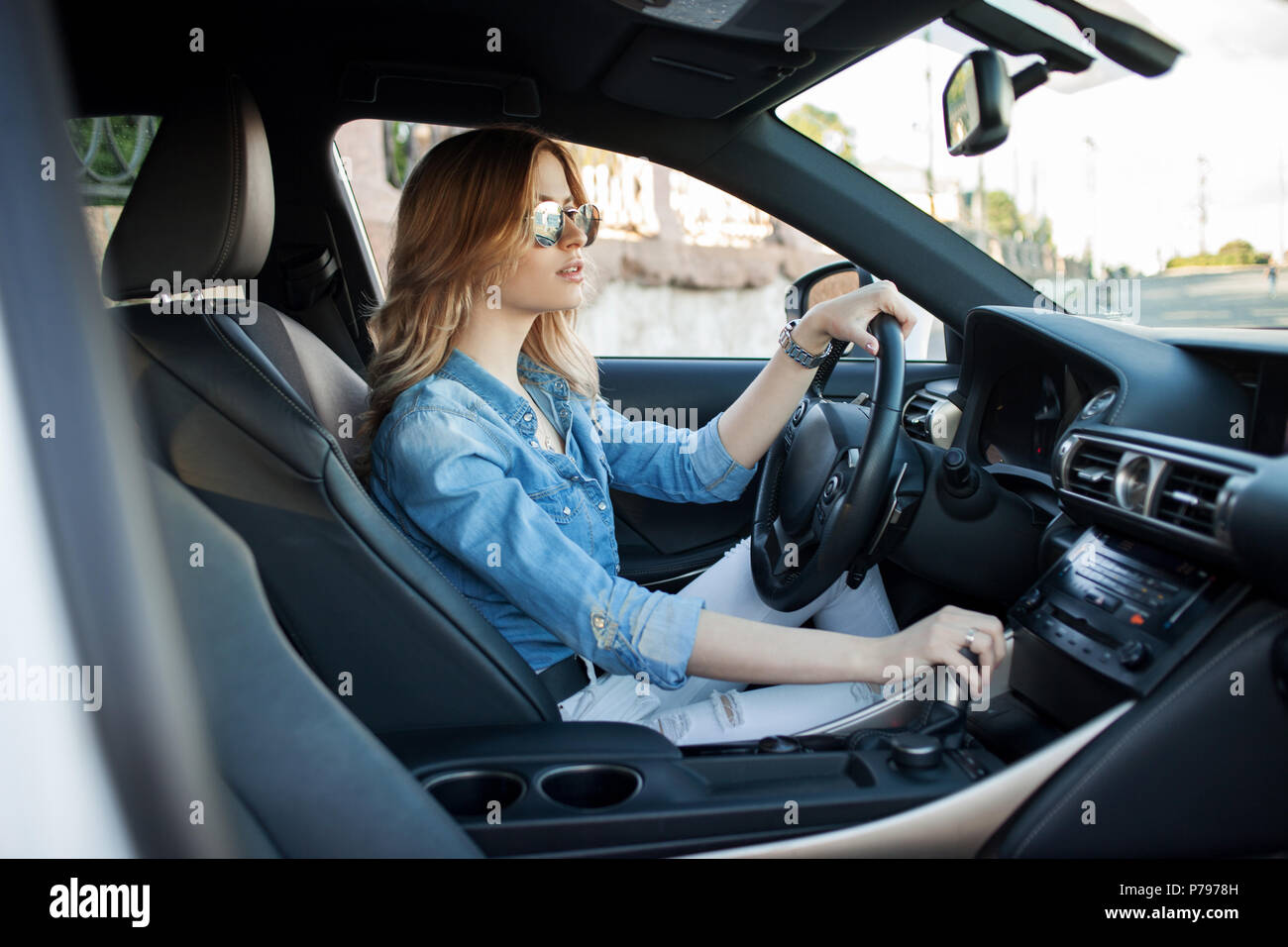 Young attractive woman driving her car. Portrait of a successful ...