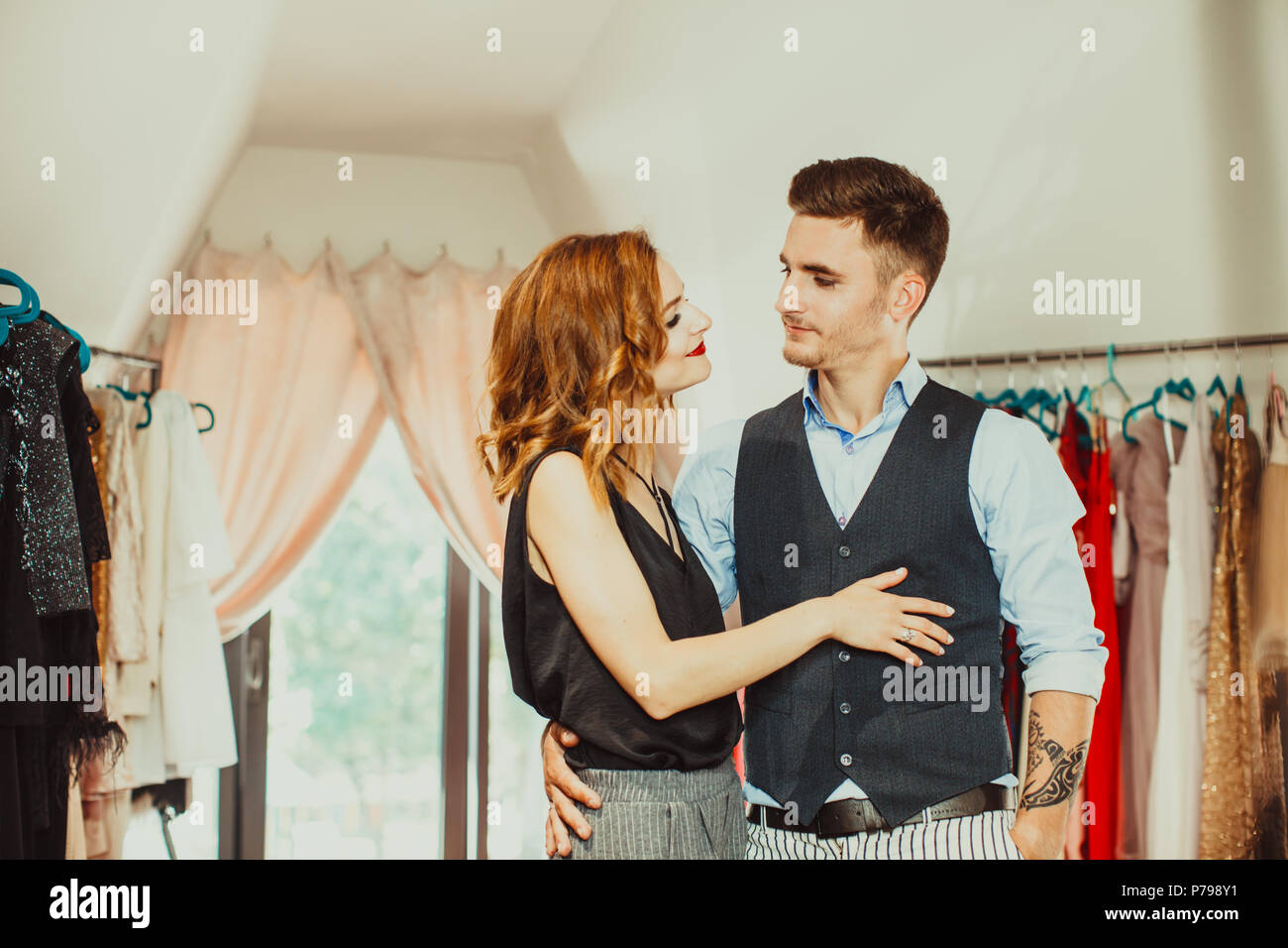 Husband helps to choose dress for his wife Stock Photo - Alamy
