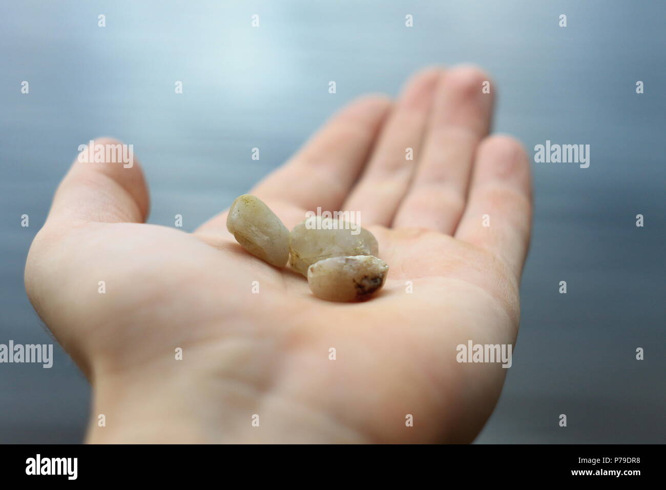 Three stones on the hand Stock Photo - Alamy