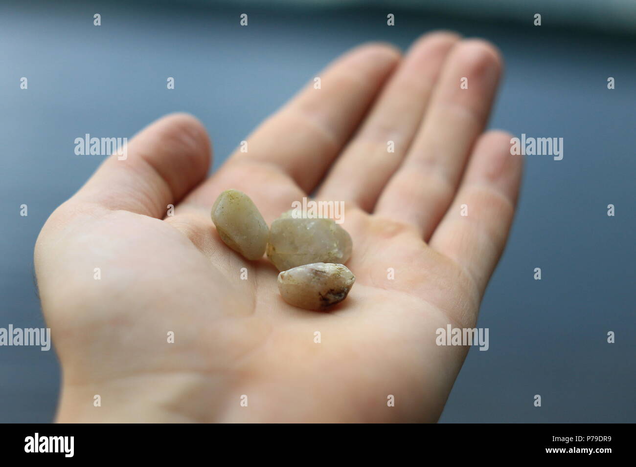 Three stones on the hand Stock Photo - Alamy