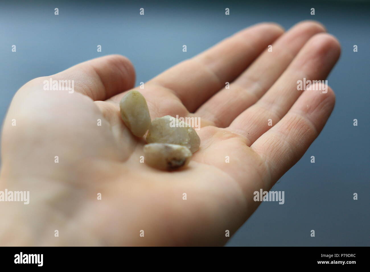Three stones on the hand Stock Photo - Alamy