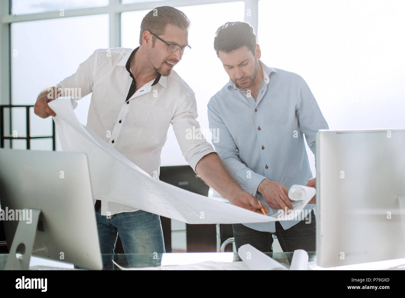 employees discussing drawings for new project Stock Photo - Alamy