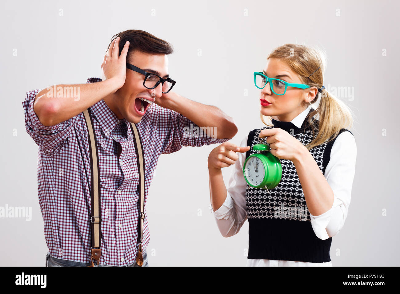 Nerdy woman showing clock to her nerdy boyfriend Stock Photo - Alamy