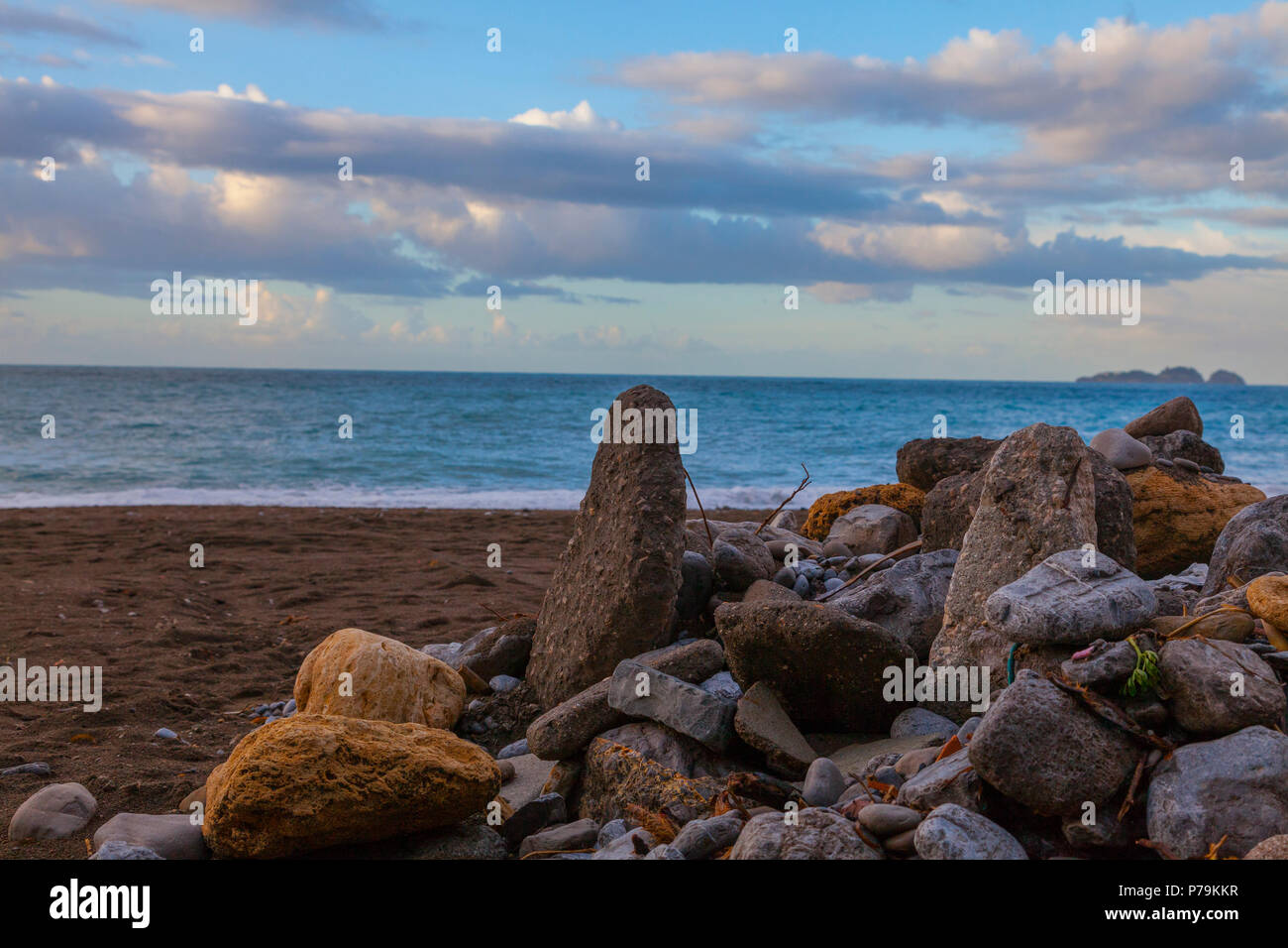 Rock Pile on Blue Water Beach Stock Photo - Alamy
