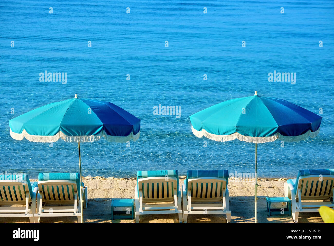 Tropical beach with sun chairs and umbrellas Stock Photo - Alamy