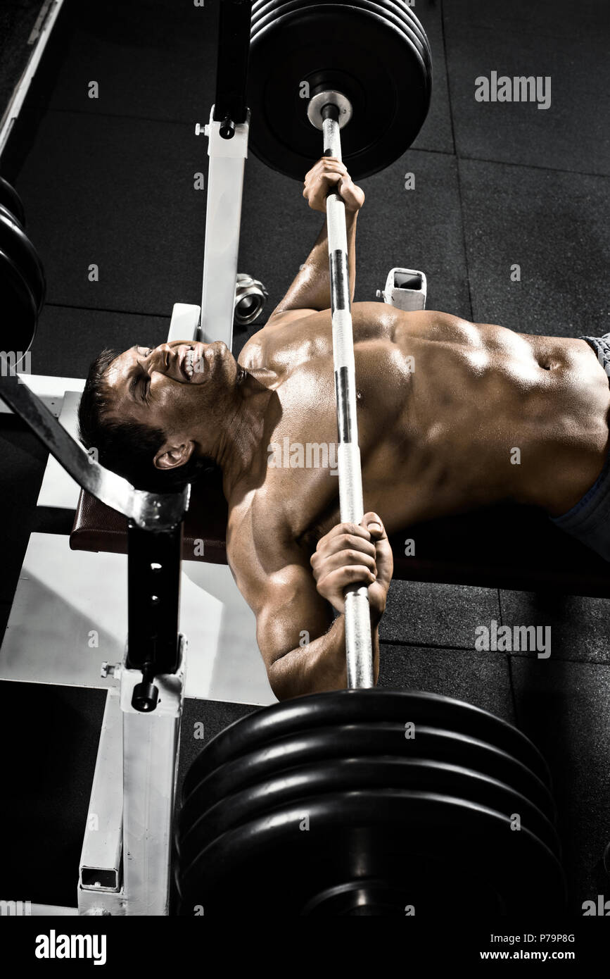 very power athletic guy , execute exercise press with weight, in sport ...