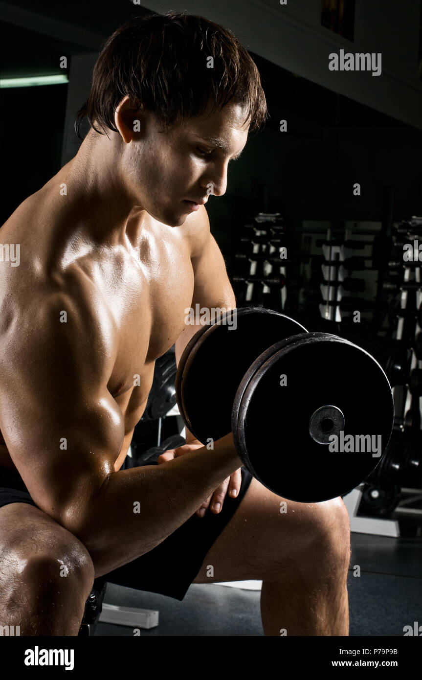 very power athletic guy , execute exercise press with dumbbells ...