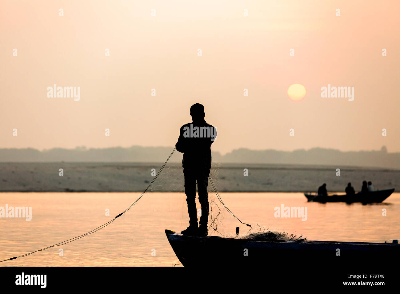 Fisherman throws net in the sunrise on Ganges river, Varanasi, Uttar ...