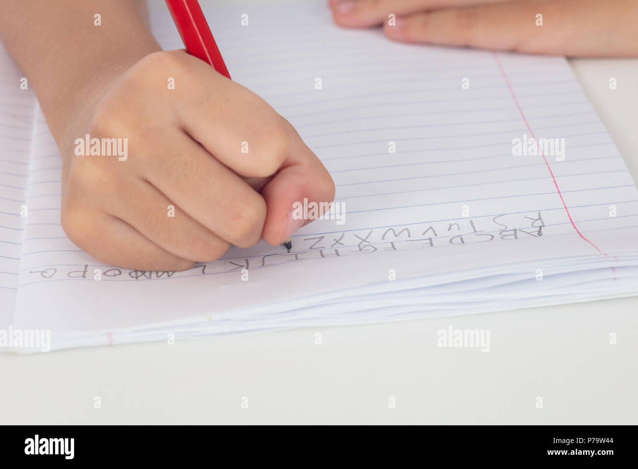 Children's hands holding pencil and doing homework in isolated white ...