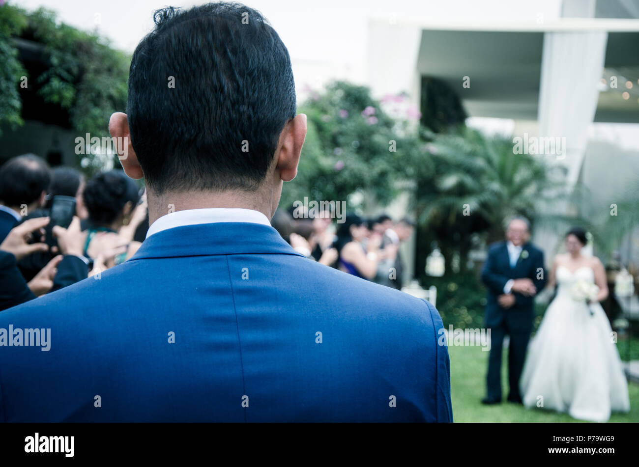 Outdoor Groom is waiting for bride who is coming with her dad in the ...