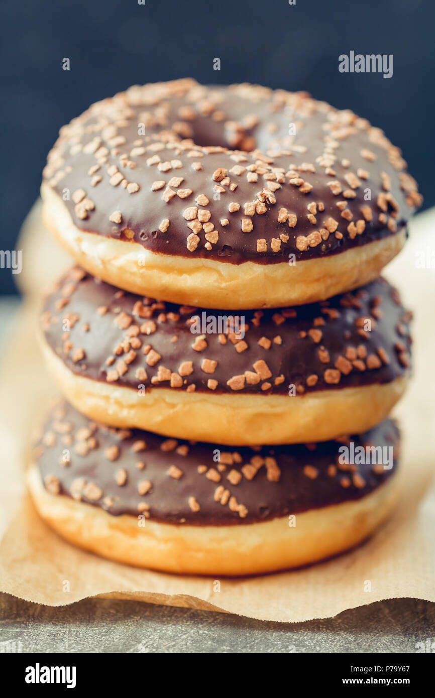 Stack of sweet chocolate donuts against black wall Stock Photo - Alamy