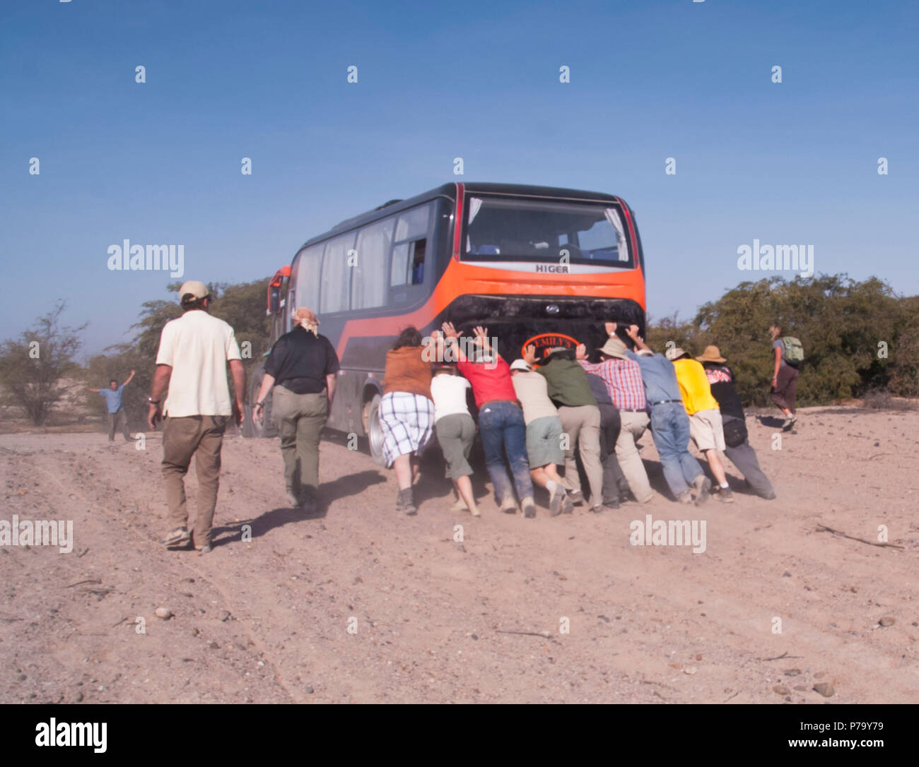The Big Push. Tourists in Peru pushing their touring bus out of the ...