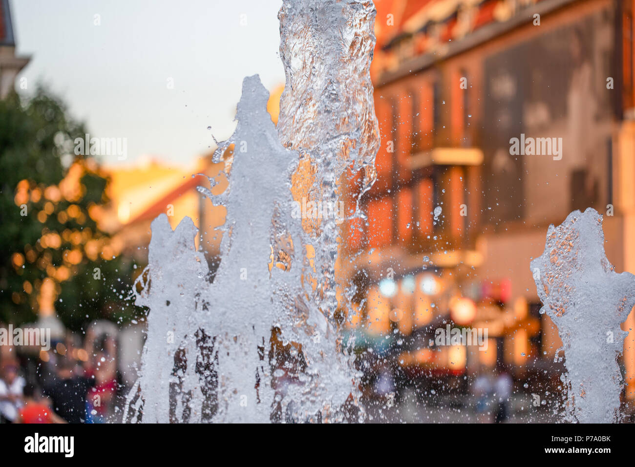 Fountain spurt, water drops, main street in the city as a background ...