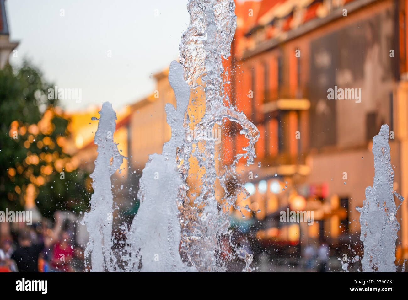Fountain spurt, water drops, main street in the city as a background ...
