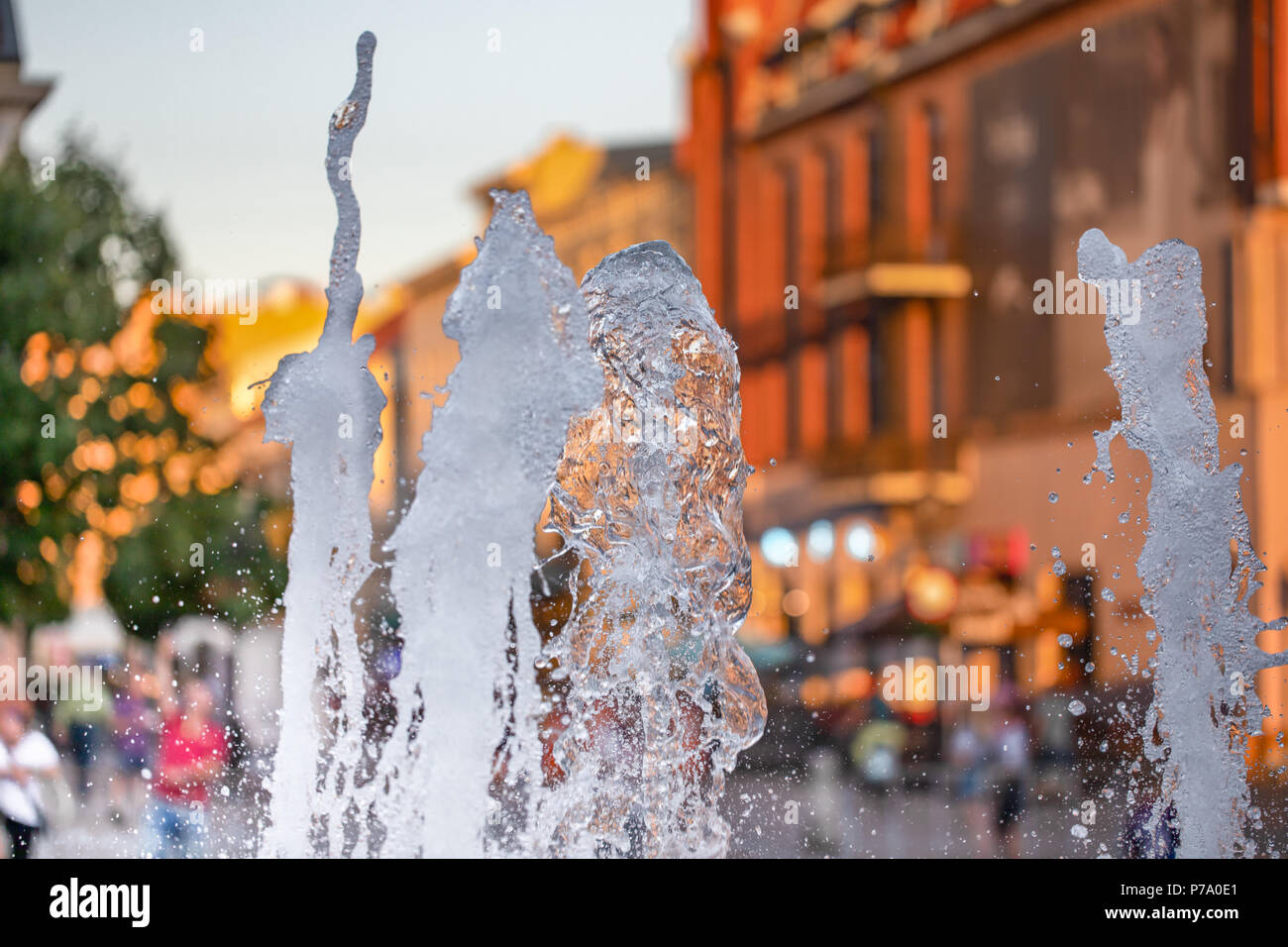 Fountain spurt, water drops, main street in the city as a background ...
