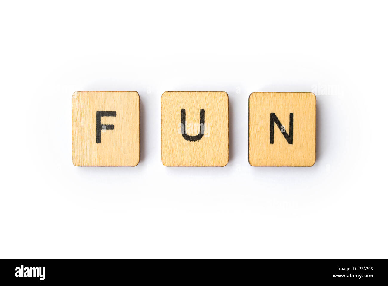 The word FUN spelt out with wooden lettered tiles Stock Photo - Alamy