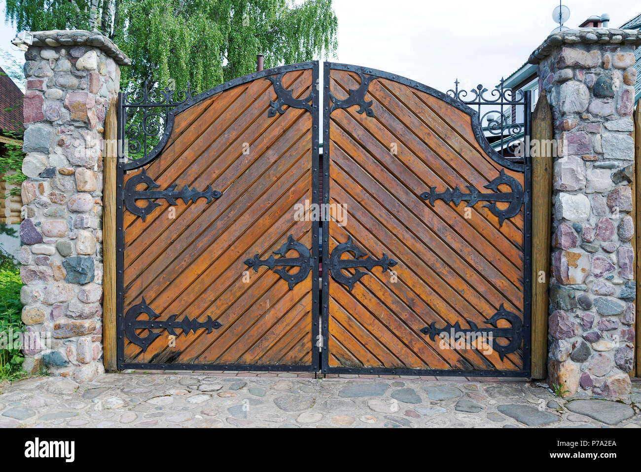 Wooden gate with wrought iron elements. Entry for cars Stock Photo - Alamy
