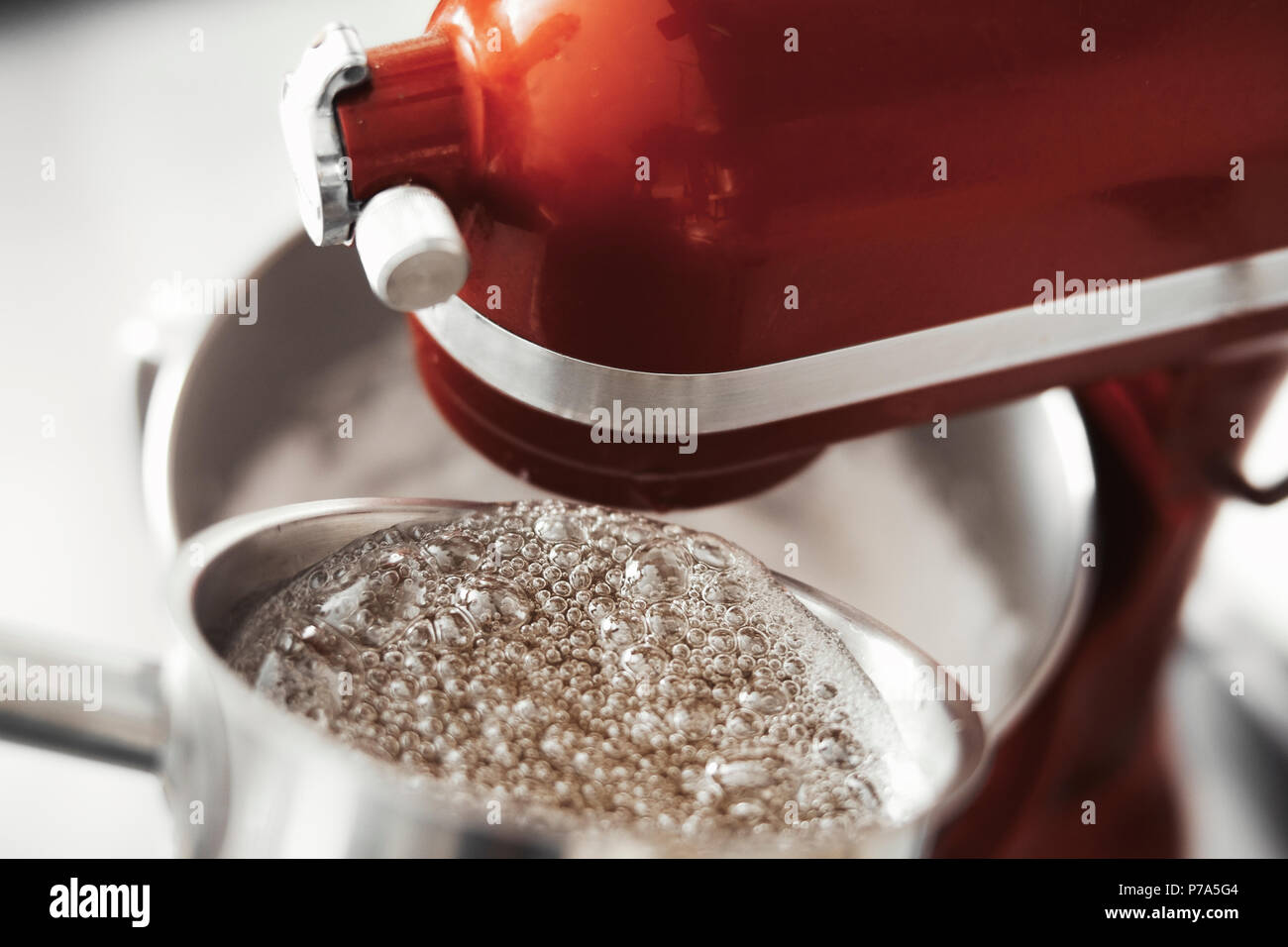 Red mixer and boiling sugar syrup in metal pot Stock Photo - Alamy