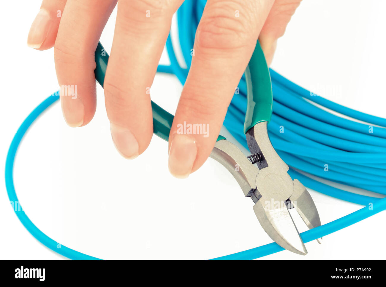 Hand with metal nippers is cutting blue cable for using in electrical ...