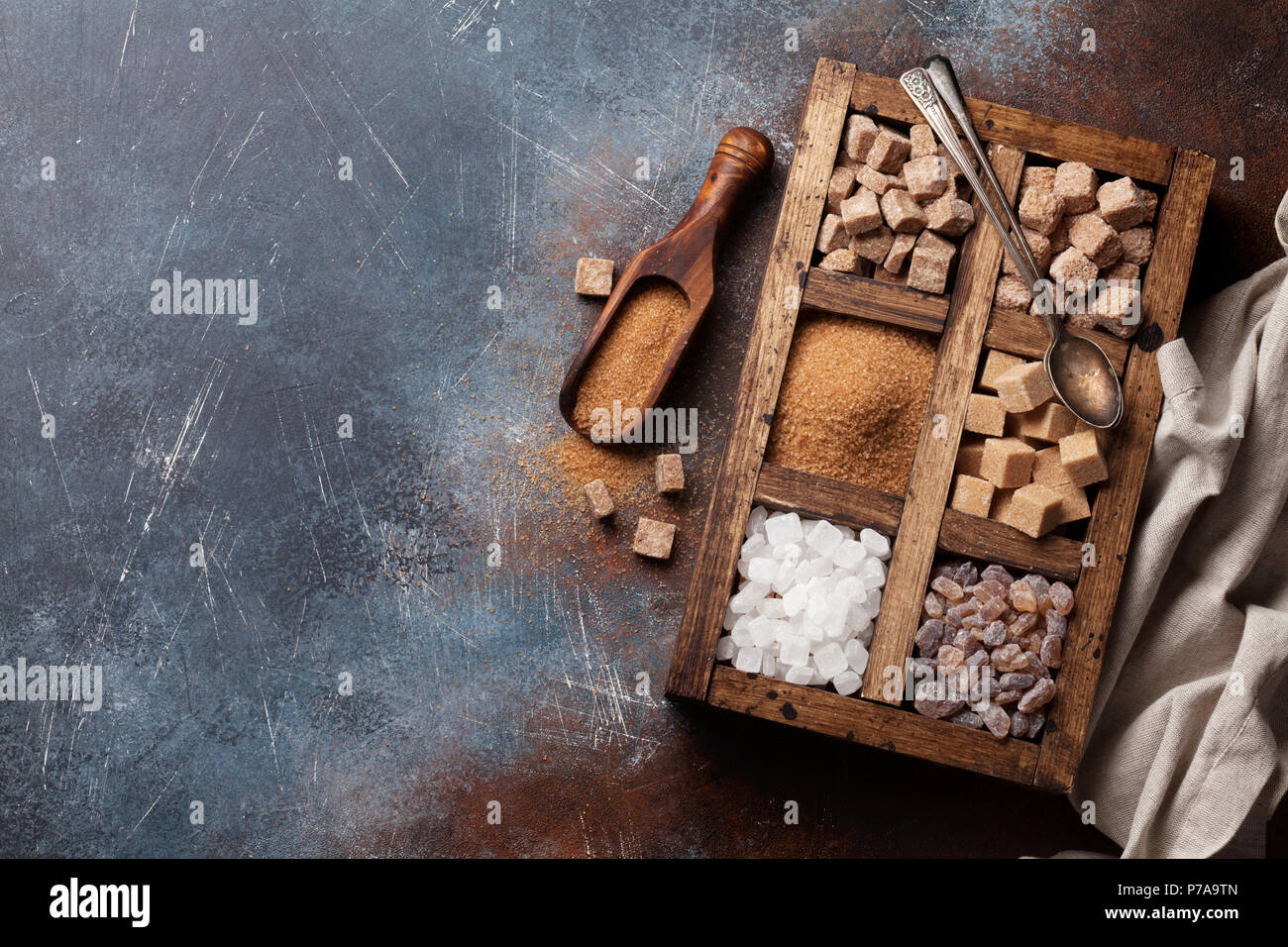 Various brown and white sugar in wooden box. Top view with space for ...