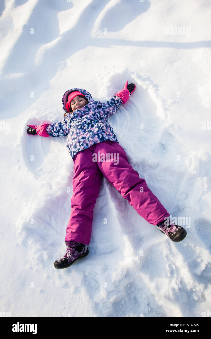 Girl makes snow angel Stock Photo - Alamy