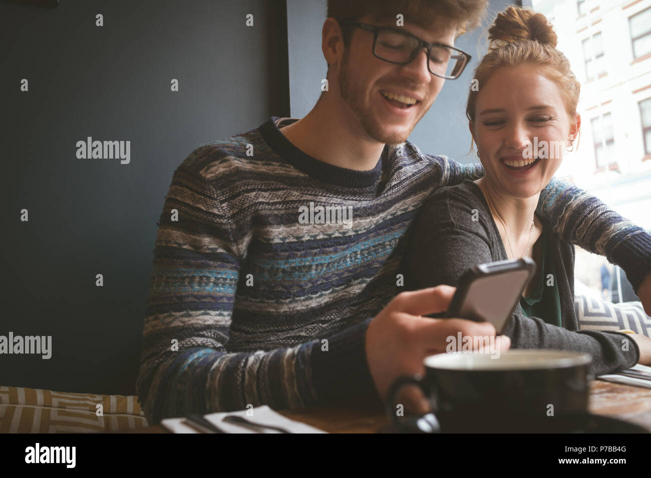 Woman with mobile phone embracing man hi-res stock photography and ...