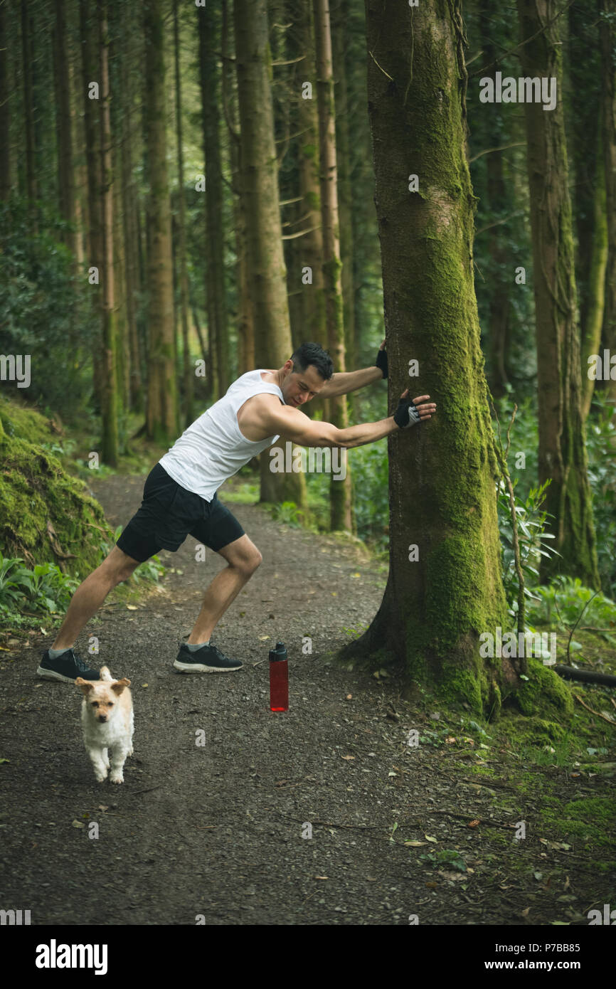 Fit man doing stretching exercise with his dog Stock Photo - Alamy