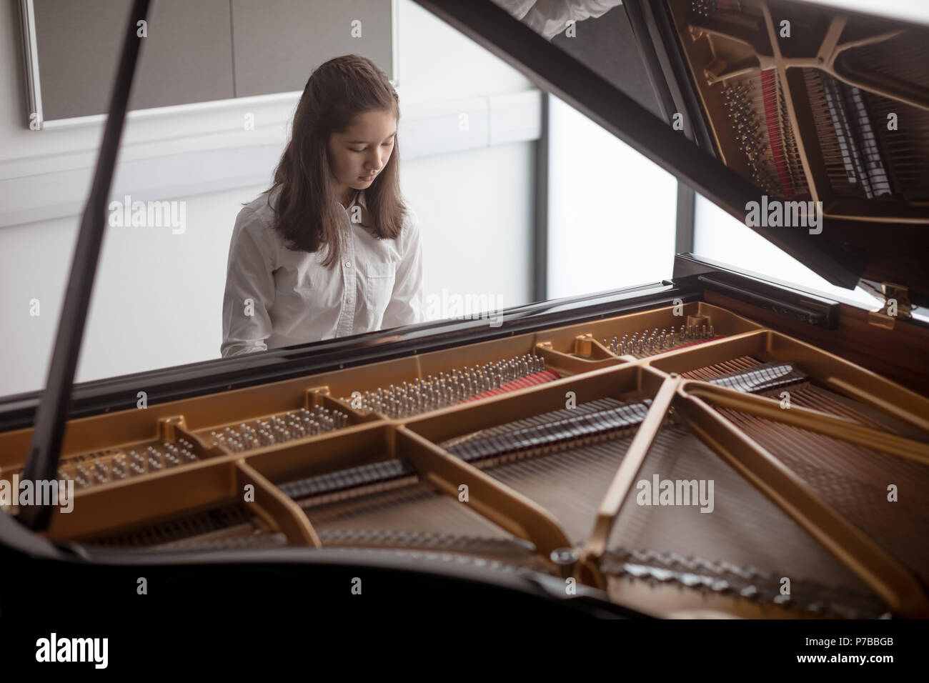 Schoolgirl playing piano in music school Stock Photo - Alamy