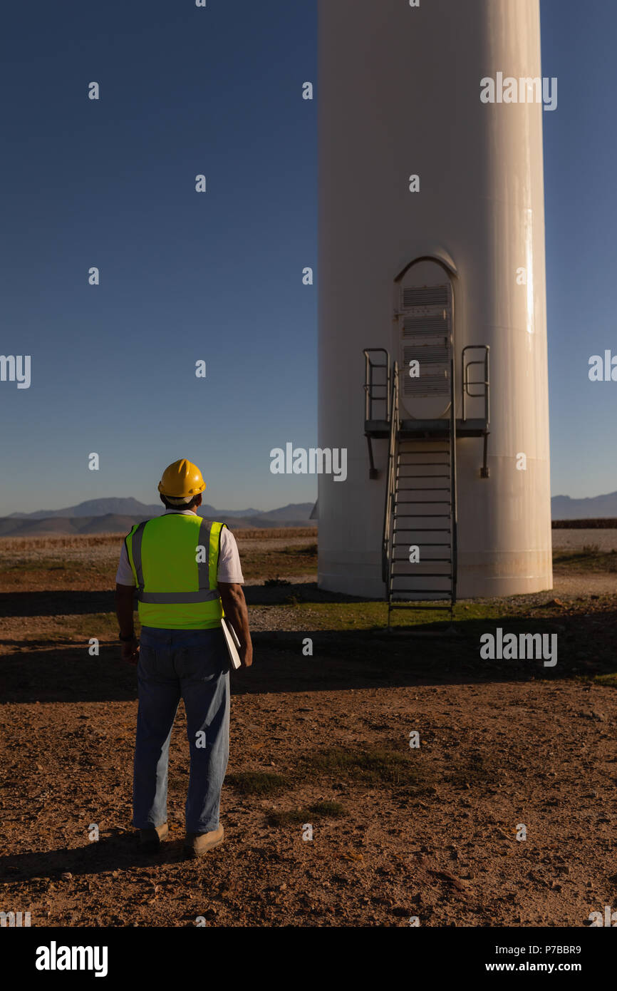 Engineer looking at a wind mill at a wind farm Stock Photo - Alamy