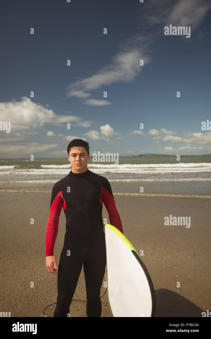Surfer with surfboard standing at beach Stock Photo - Alamy