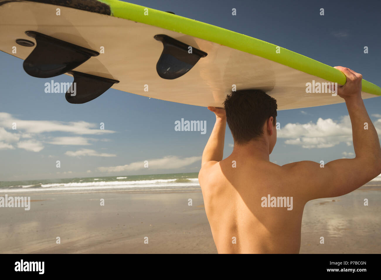 Surfer carrying the surfboard on his head Stock Photo - Alamy