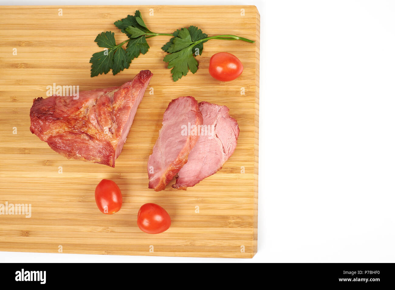 Cooked sliced pork barbecue steak on wooden cutting board on the white ...