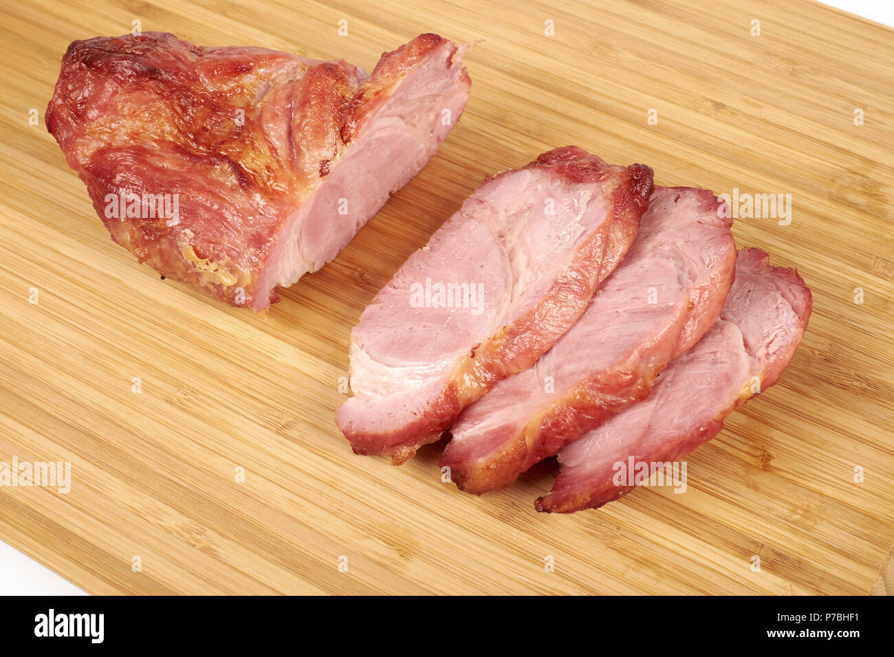 Cooked sliced pork barbecue steak on wooden cutting board on the white ...