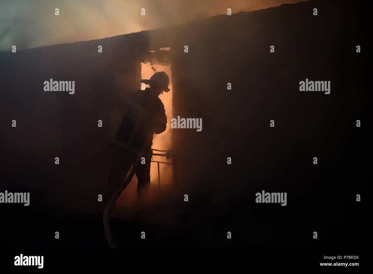 Silhouette of fireman fighting bushfire at night Stock Photo - Alamy