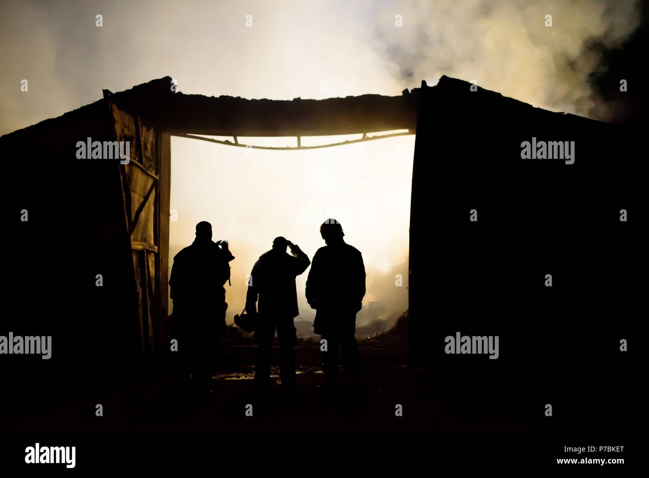 Silhouette of fireman fighting bushfire at night Stock Photo - Alamy