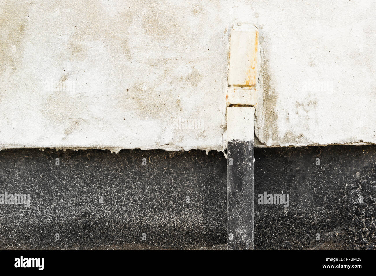 Part of a drainage pipe in a white wall with rusty watermarks Stock ...