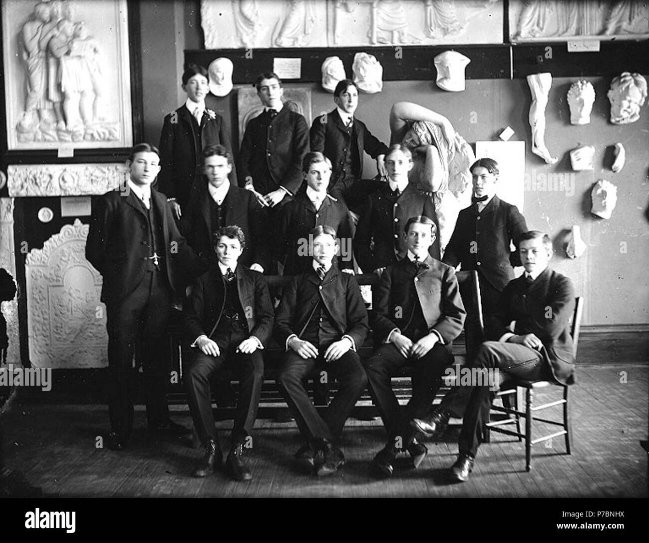. English: Young men posed for group portrait in museum or gallery ...