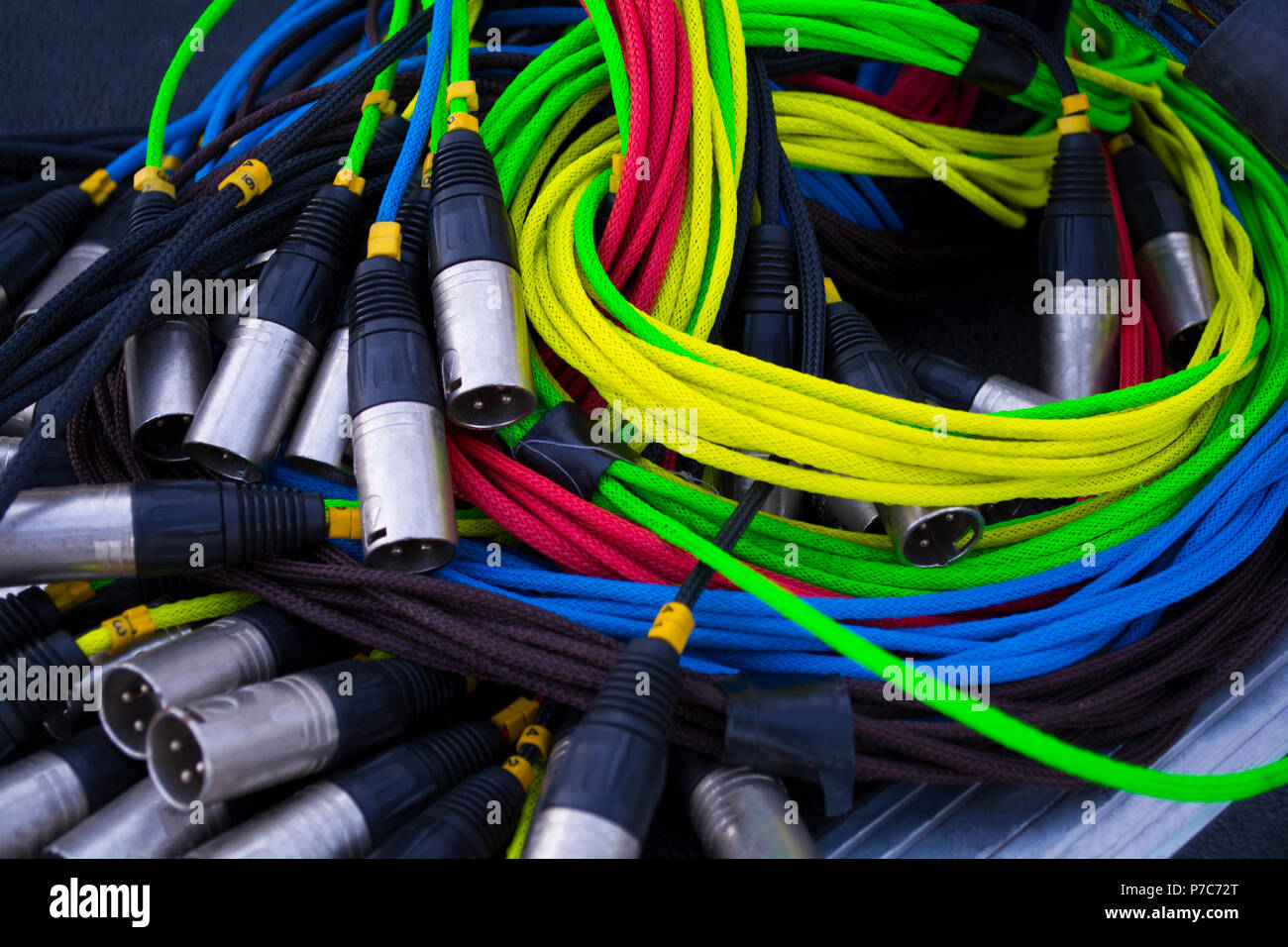 colorful sound and light signal cables on black stage case, shallow ...