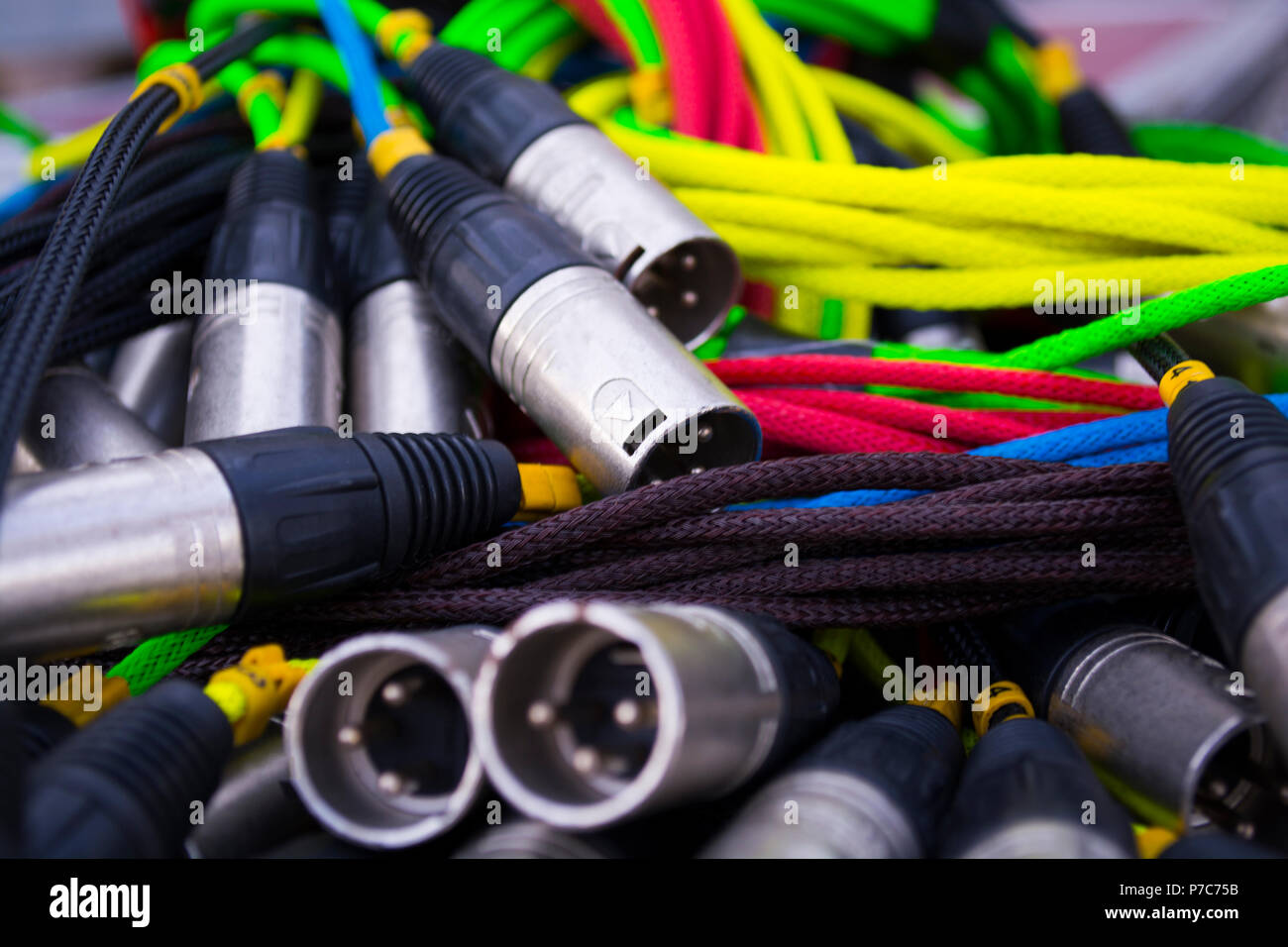 colorful sound and light signal cables on black stage case, shallow ...