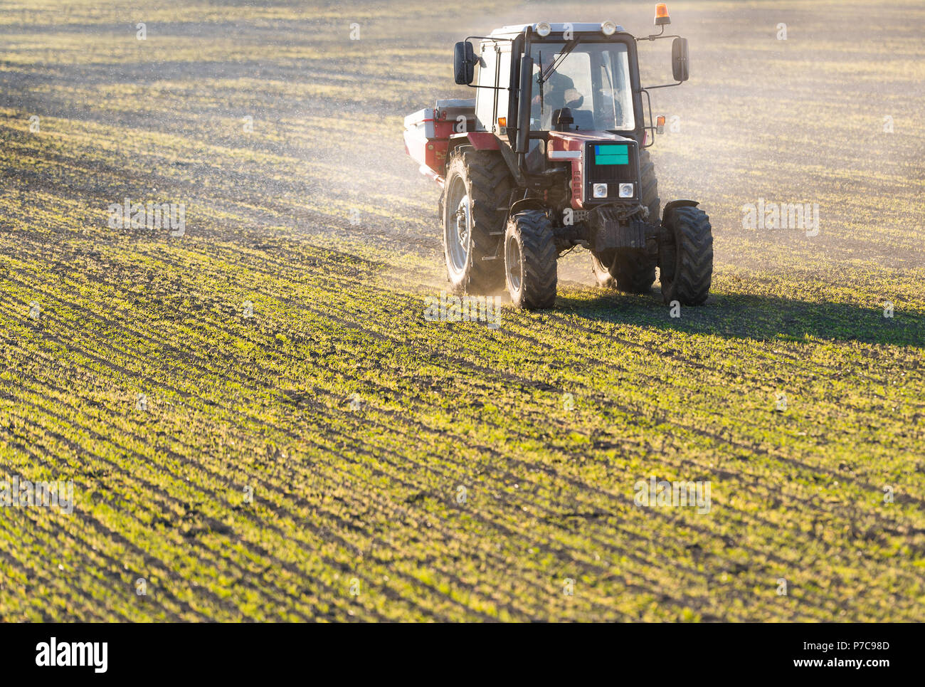 Tractor spreading artificial fertilizers in field Stock Photo - Alamy