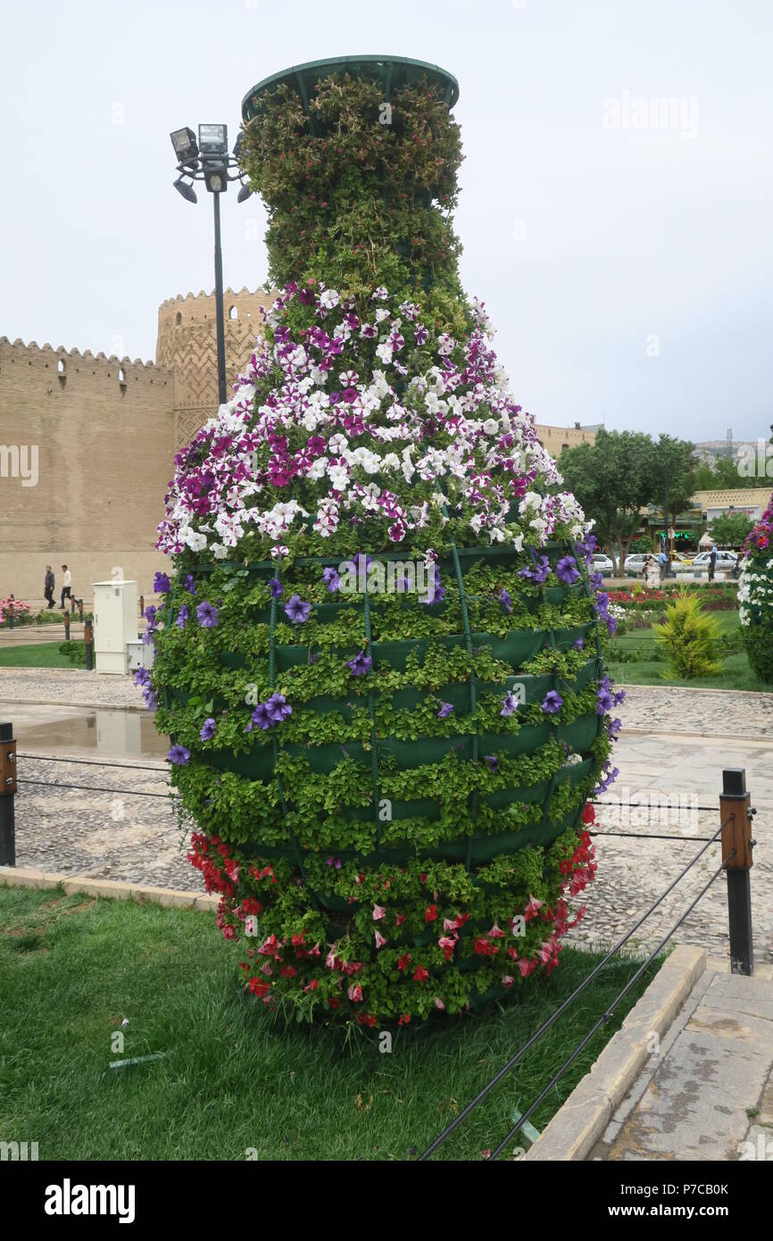 Huge vase of flowers, Arg Karim Khan castle on background, Shiraz, Iran ...