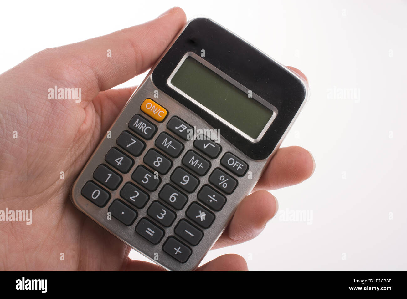 Hand holding a calculator on a white background Stock Photo - Alamy