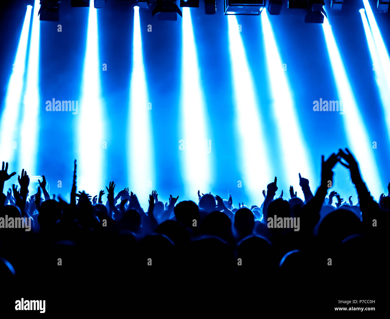 cheering crowd at rock concert in front of bright lights Stock Photo ...