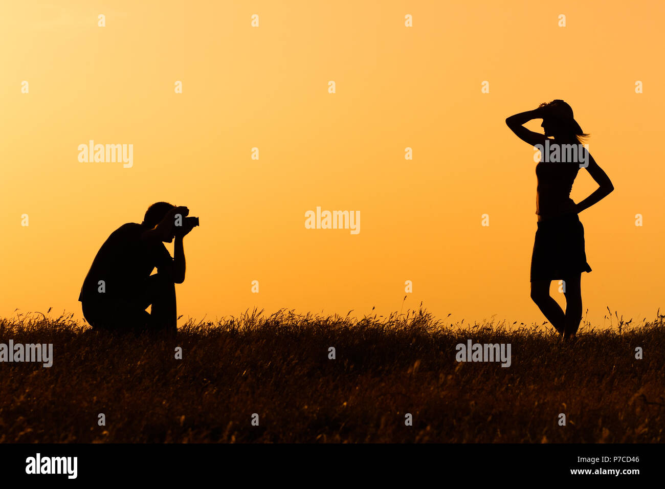Silhouette of a man photographing woman Stock Photo - Alamy