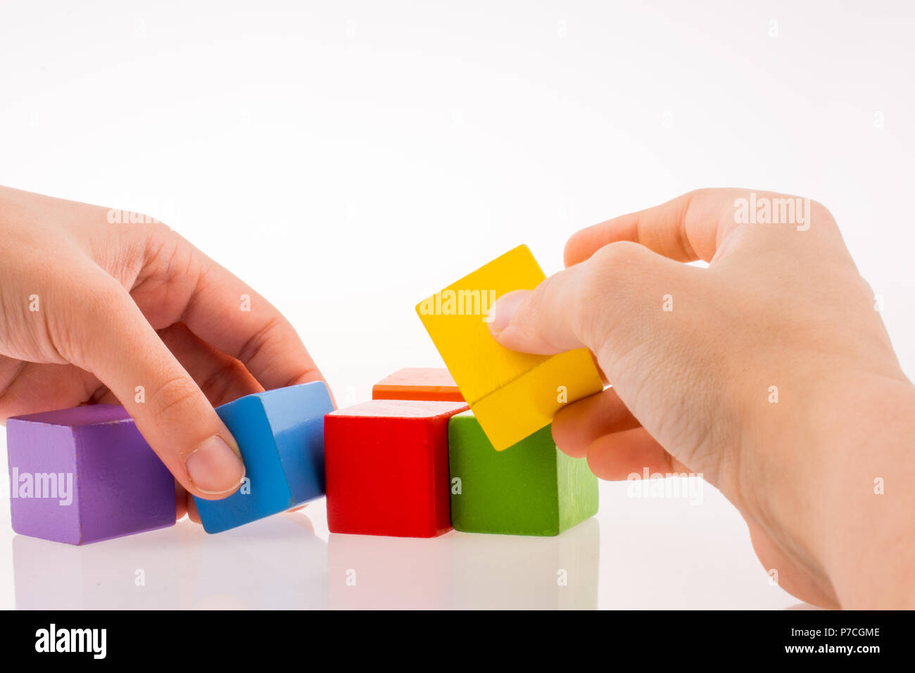 Hand playing with colorful cubes on a white background Stock Photo - Alamy